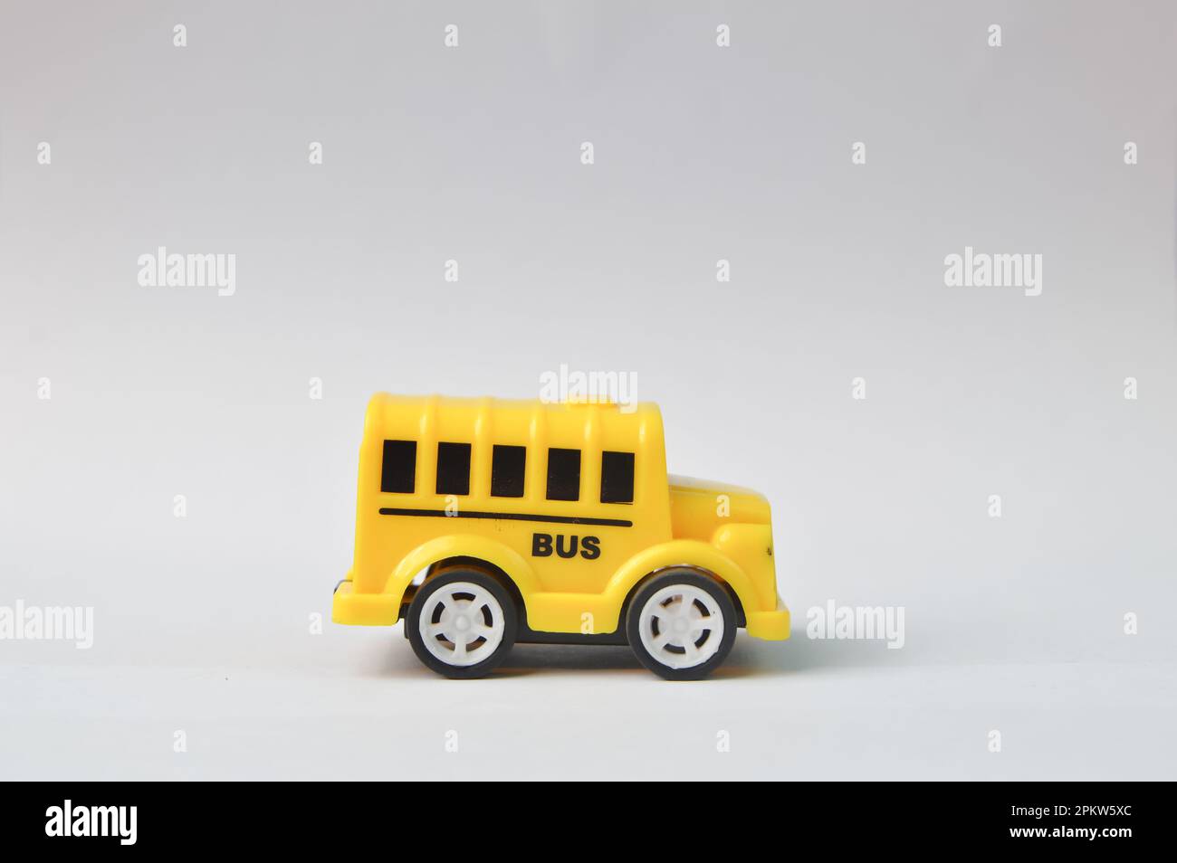 Yellow toy bus isolated on a white background Stock Photo - Alamy