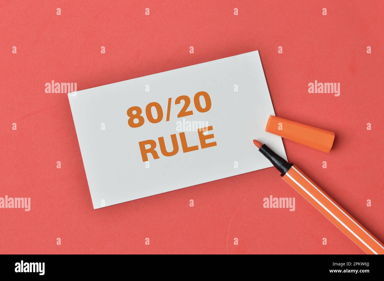 Top view of white paper written with 80 20 rule over red background ...