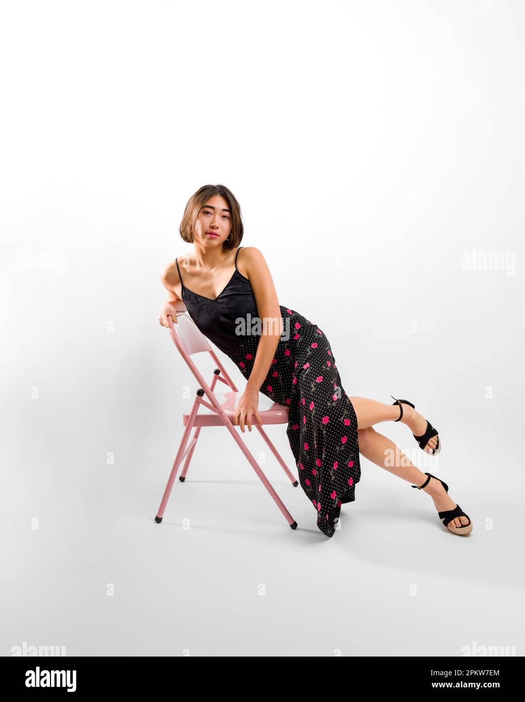 Young Asian Woman Sitting on a Pink Chair in Studio | White Backdrop ...