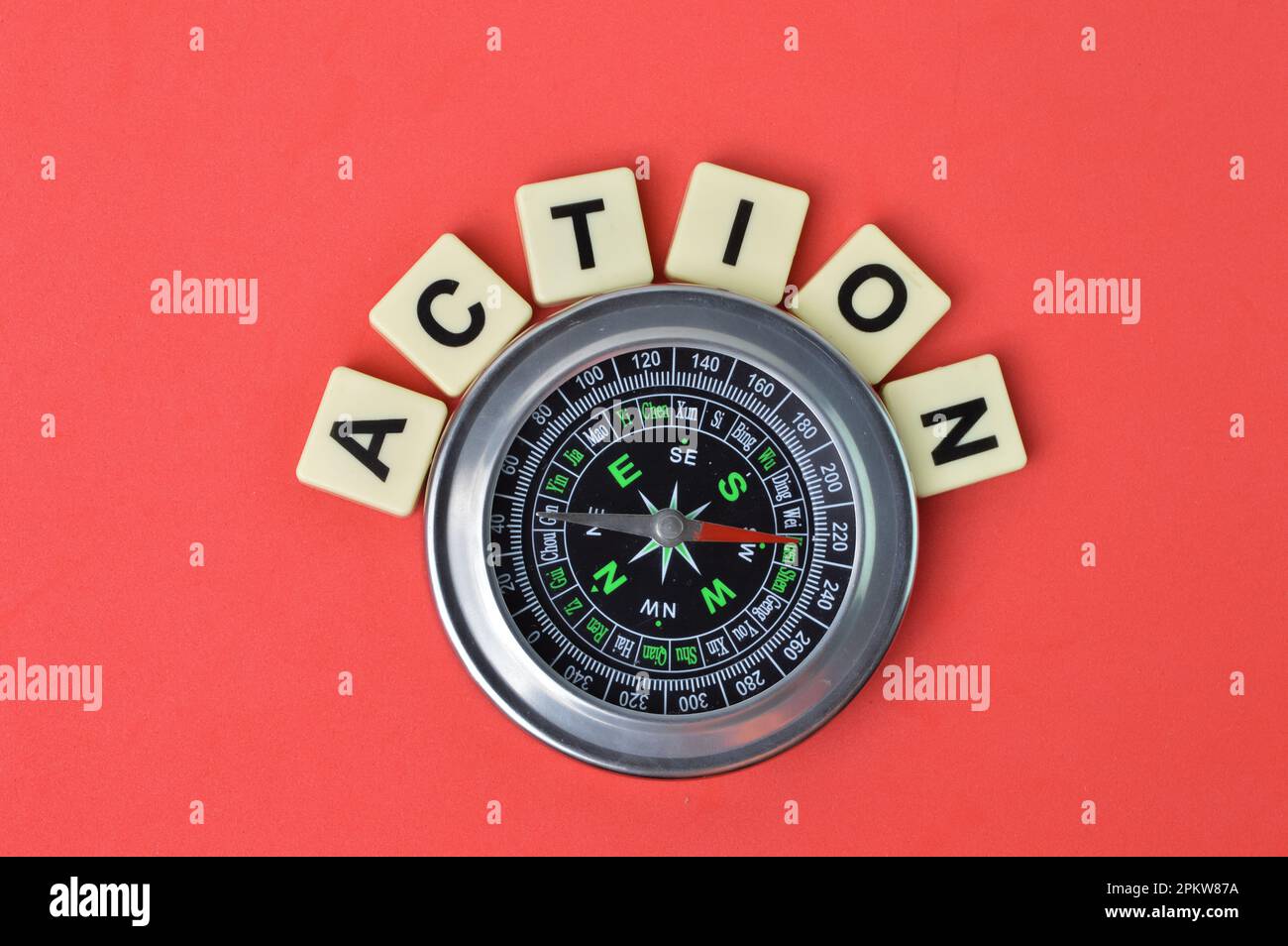 Compass and square letters with text ACTION Stock Photo - Alamy