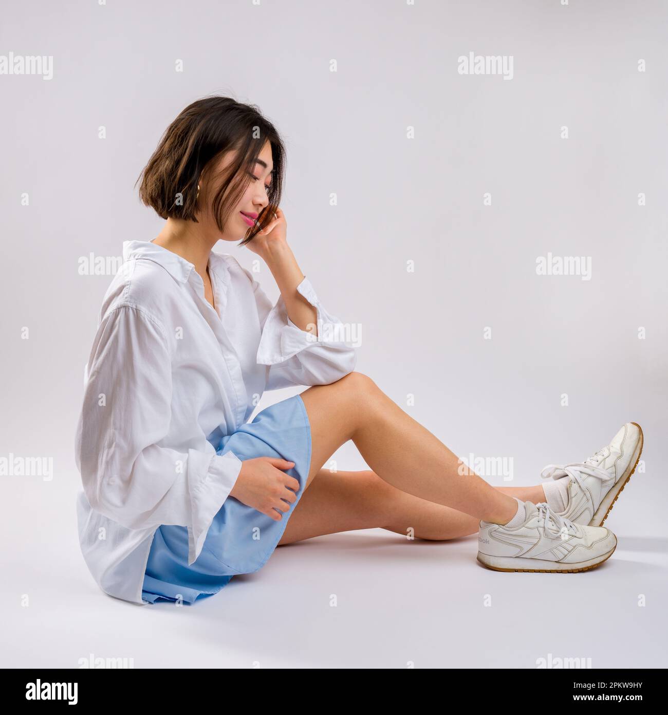 Full Body Portrait of Young Asian Woman Seated on the Ground | White Backdrop | Short Blue Skirt ...