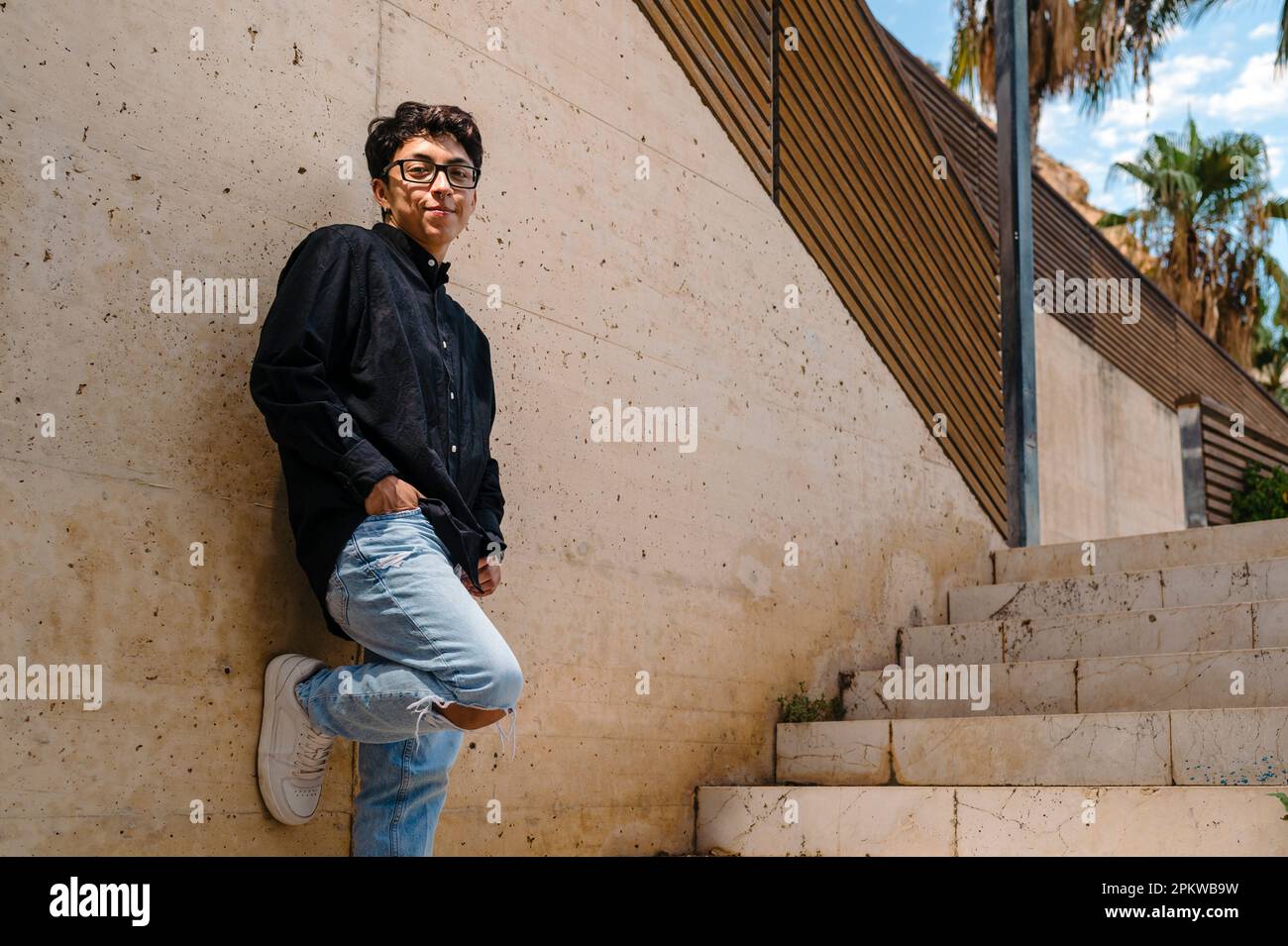 Confident transgender person posing standing outdoors on a walkway ...