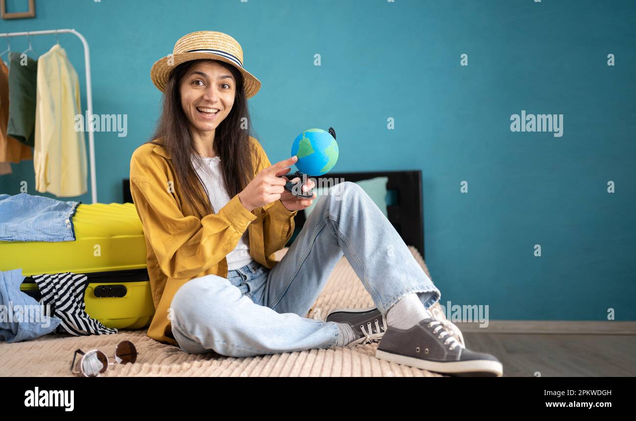 Happy woman planning holiday trip. Cheerful lady in hat choosing her ...