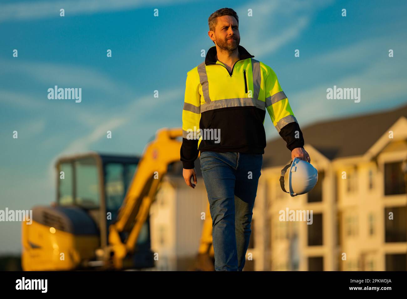 Builder in a construction site. Builder with excavator ready to build ...