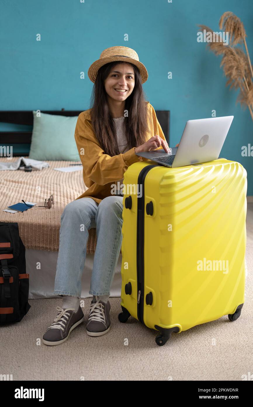 Young woman planning vacation trip and using computer to book hotel ...