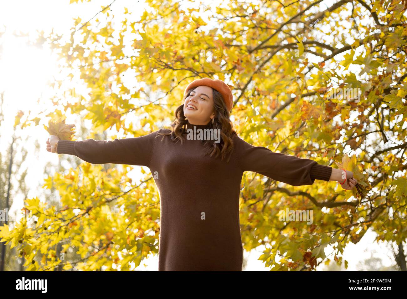 Beautiful young woman relaxing at park during autumn season. Happy girl ...