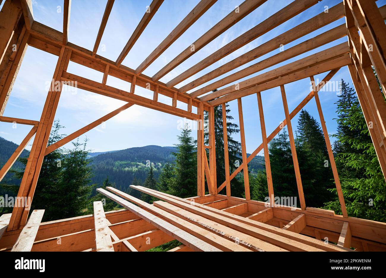 Wooden frame building under construction close to forest. Beginning of ...