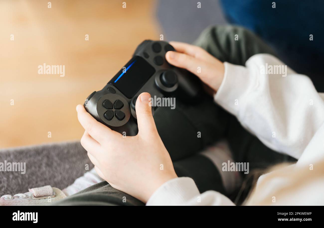 A little girl holding game controller playing video games Stock Photo ...