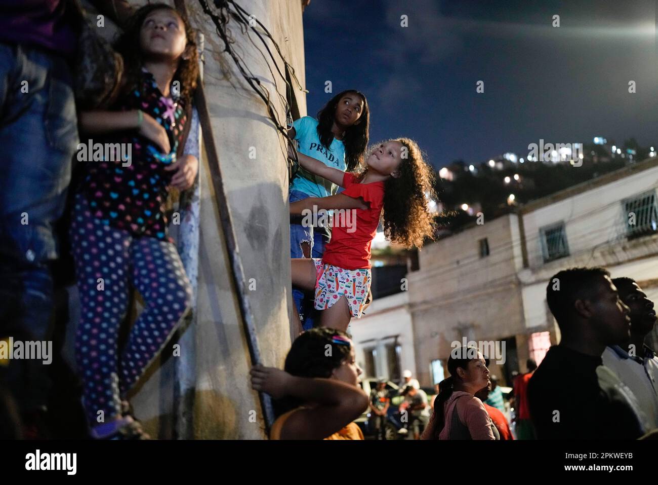 A girl hanging from a window waits to see the burn of an effigy ...