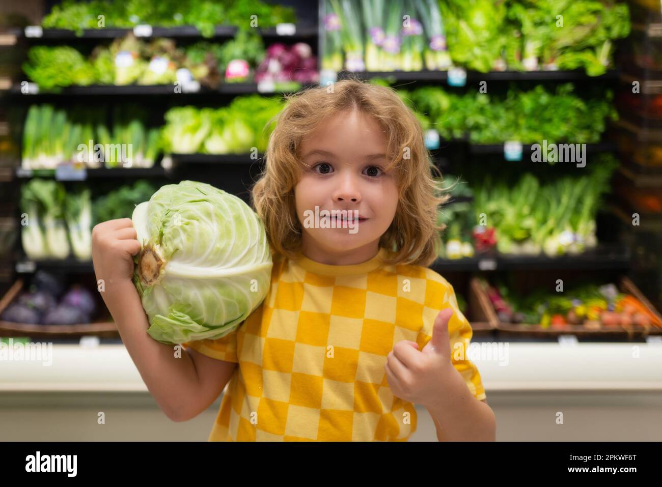 Child with cabbage. Child choosing fruits and vegetables during ...