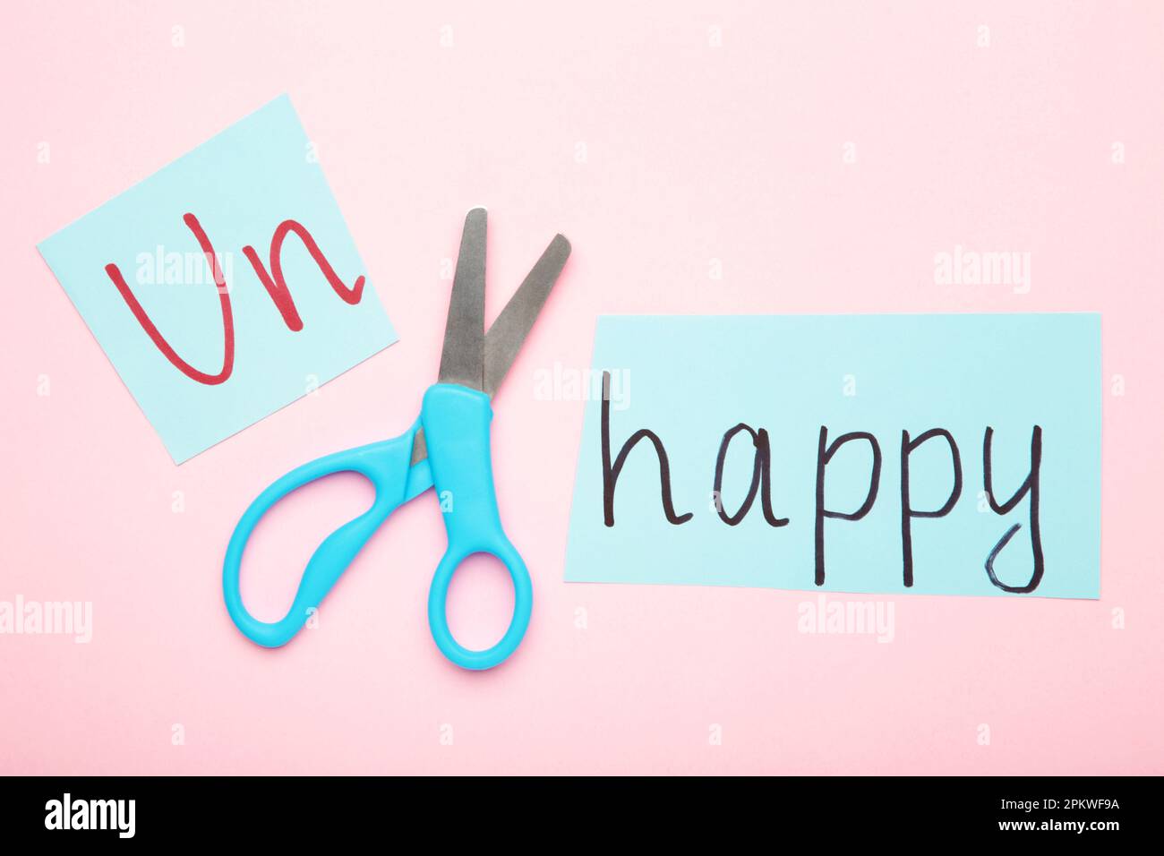 Card with the text unhappy, scissors cut the word. The concept of ...