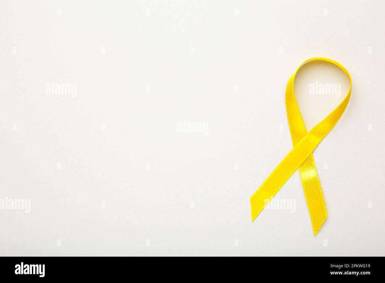 Yellow awareness ribbon on grey background. Top view Stock Photo - Alamy