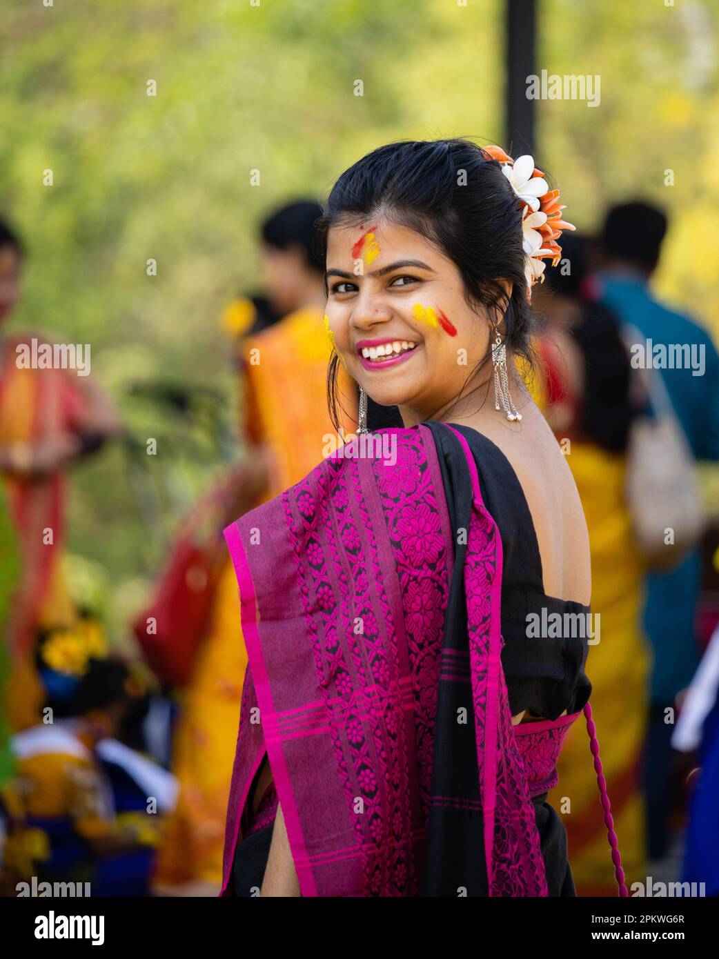 An Indian woman with colorful face looking at camera in holi - the ...