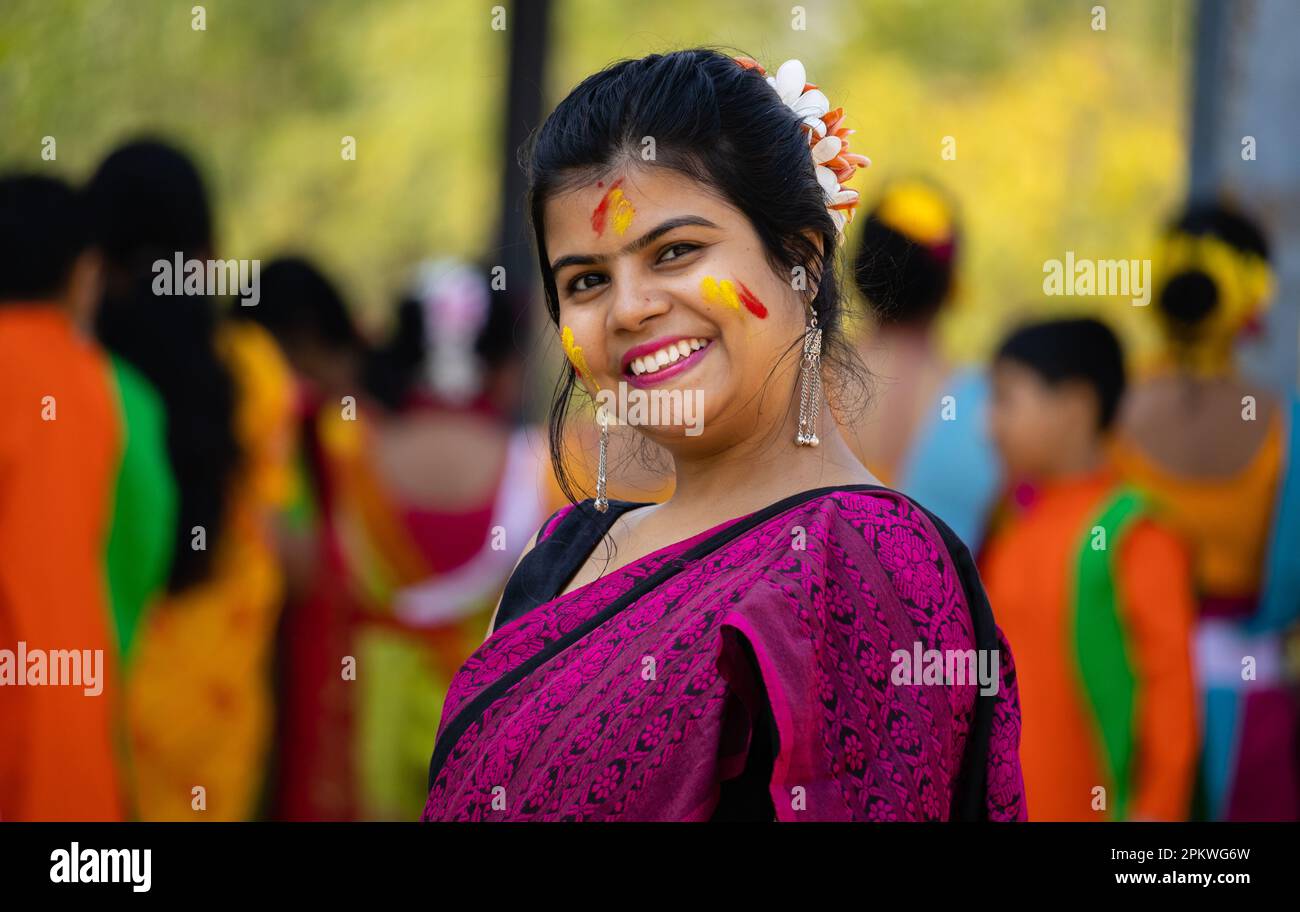 An Indian woman with colorful face looking at camera in holi - the ...
