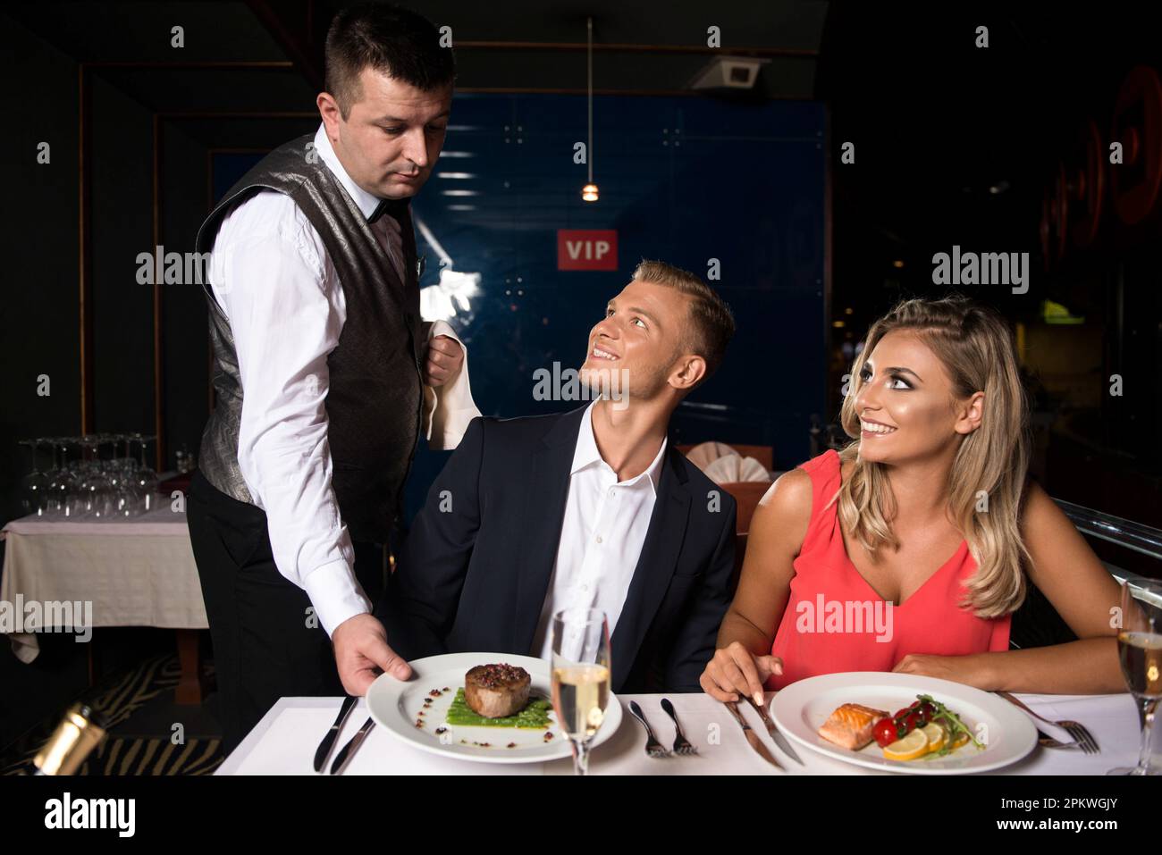 Waiter Serving Romantic Couple Friends Eating At A Restaurant Table ...