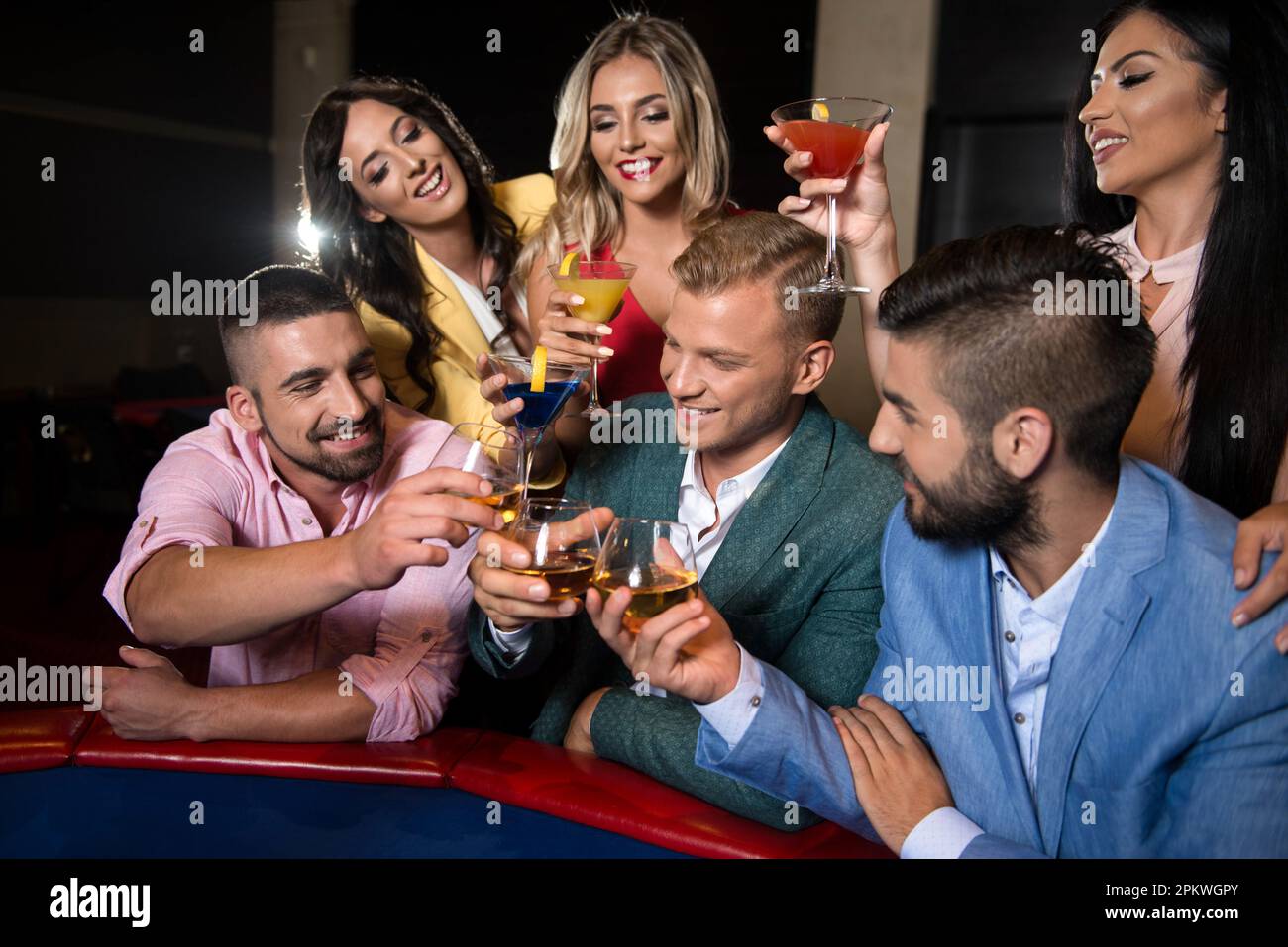 Three Couples Gamble at Night at the Roulette Table in a Casino and ...