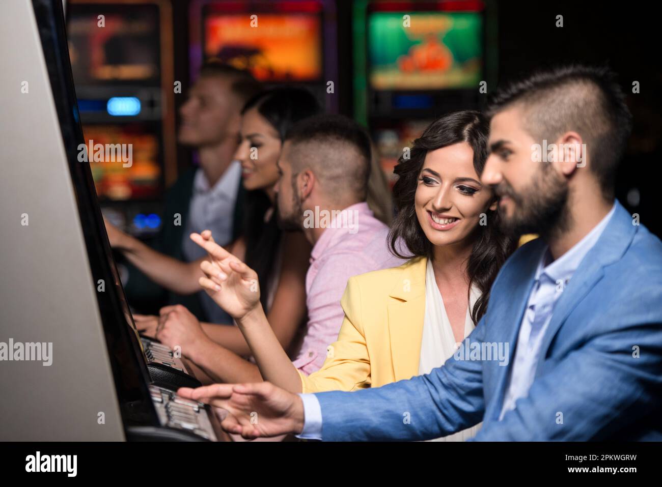 Young Group of People at the Automat Machine in a Casino and Celebrate ...