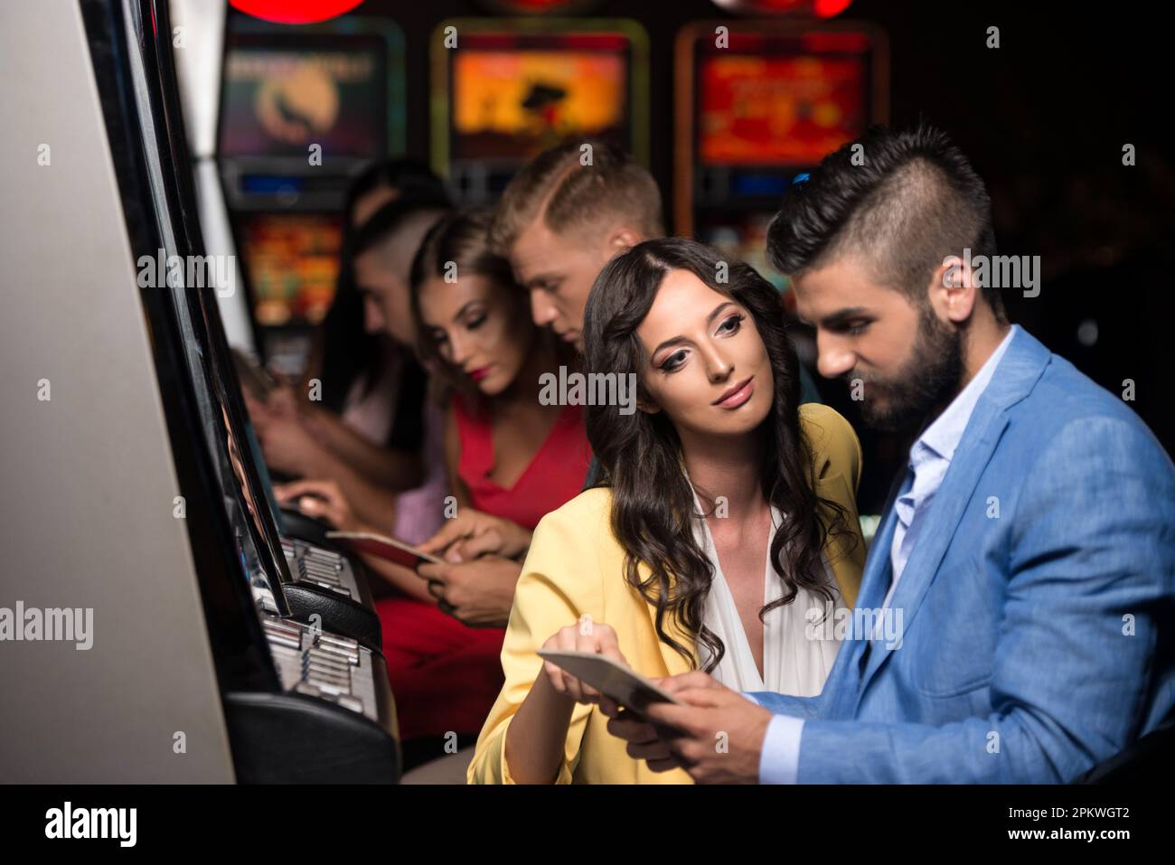 Beautiful and Well Dressed Friends Playing Automat Machine in the ...
