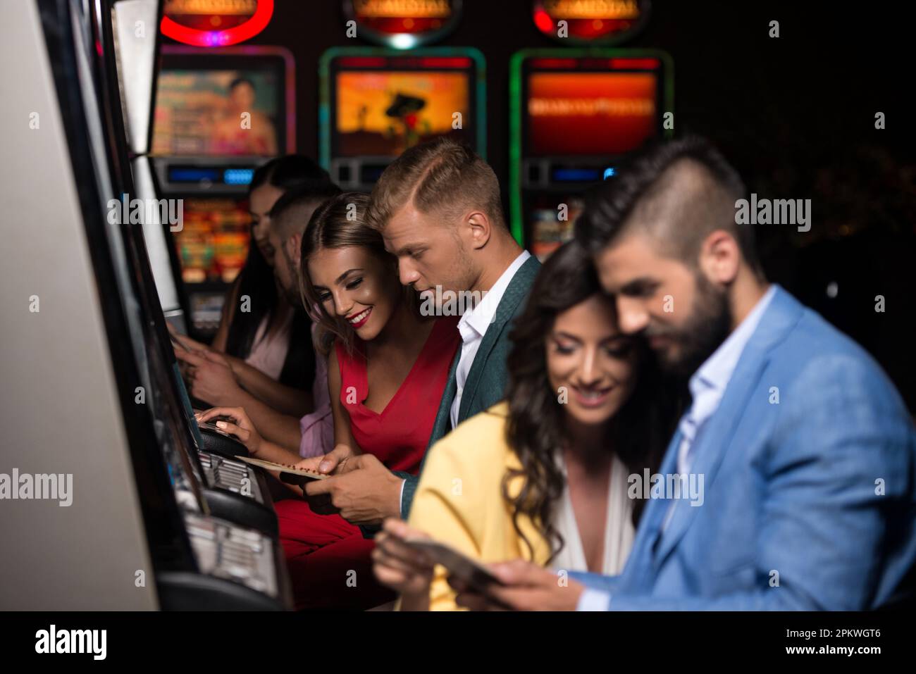 Young Group of People at the Automat Machine in a Casino and Celebrate ...