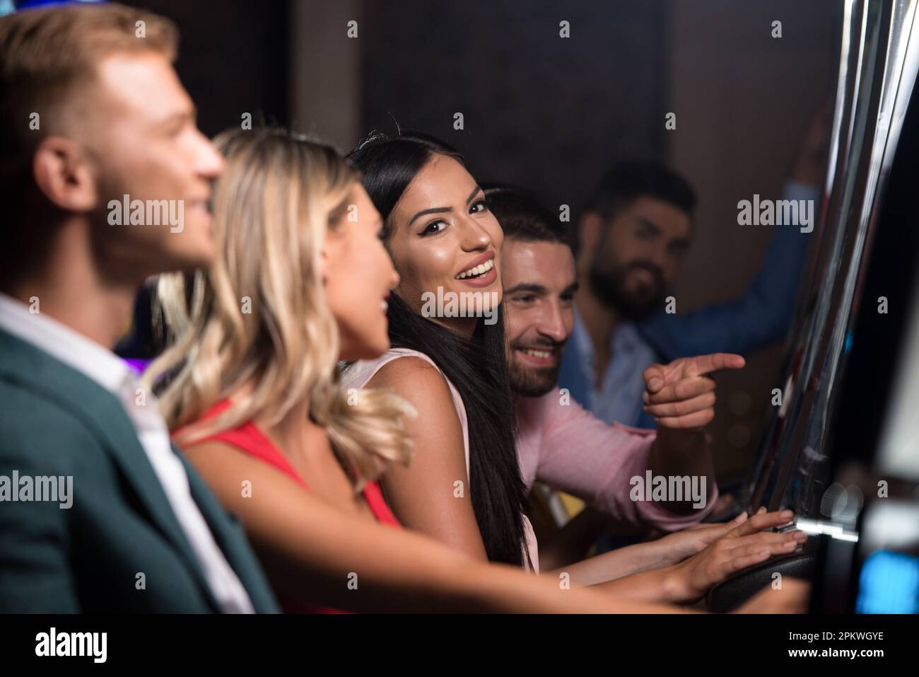 Young Group of People at the Automat Machine in a Casino and Celebrate ...