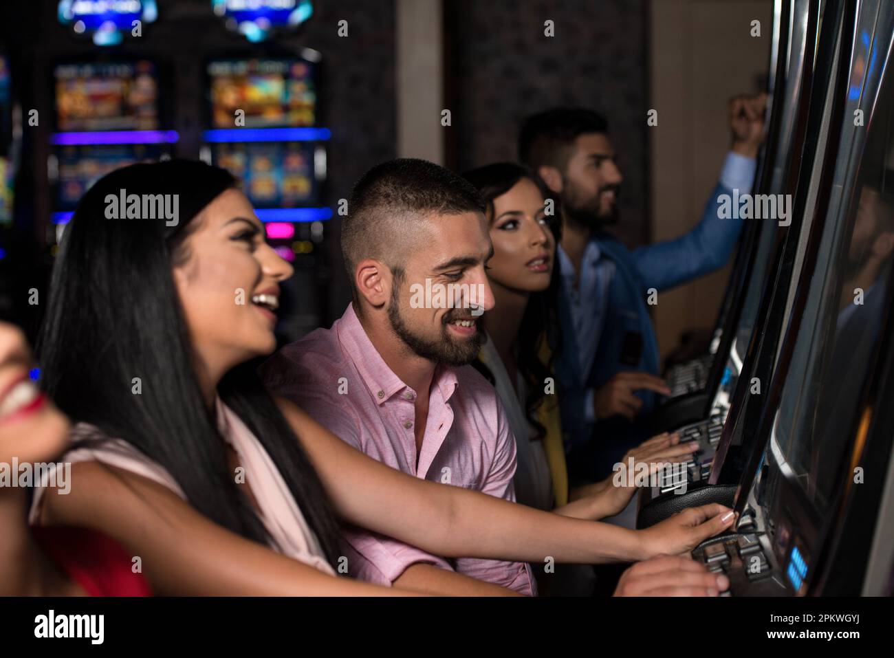 Young Group of People at the Automat Machine in a Casino and Celebrate ...