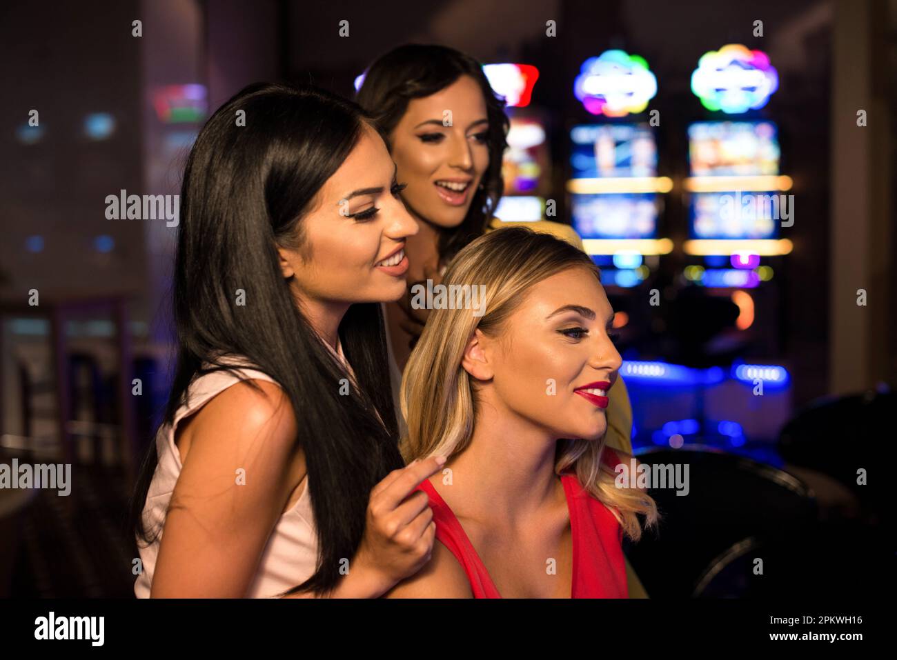 Young Women at Night at the Automat Machine in a Casino and Celebrate ...