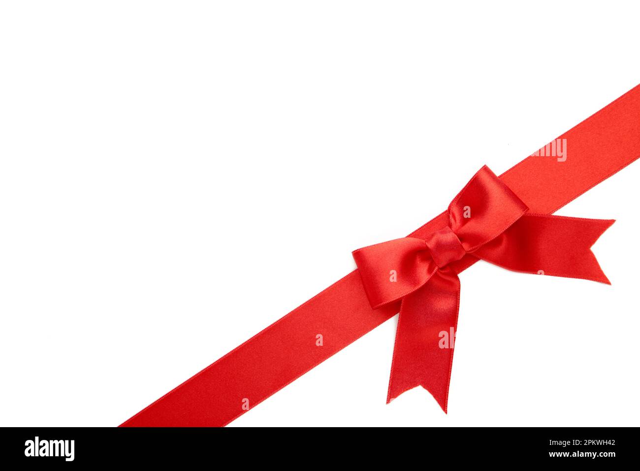 Red ribbon with bow with tails isolated on white background. Top view ...