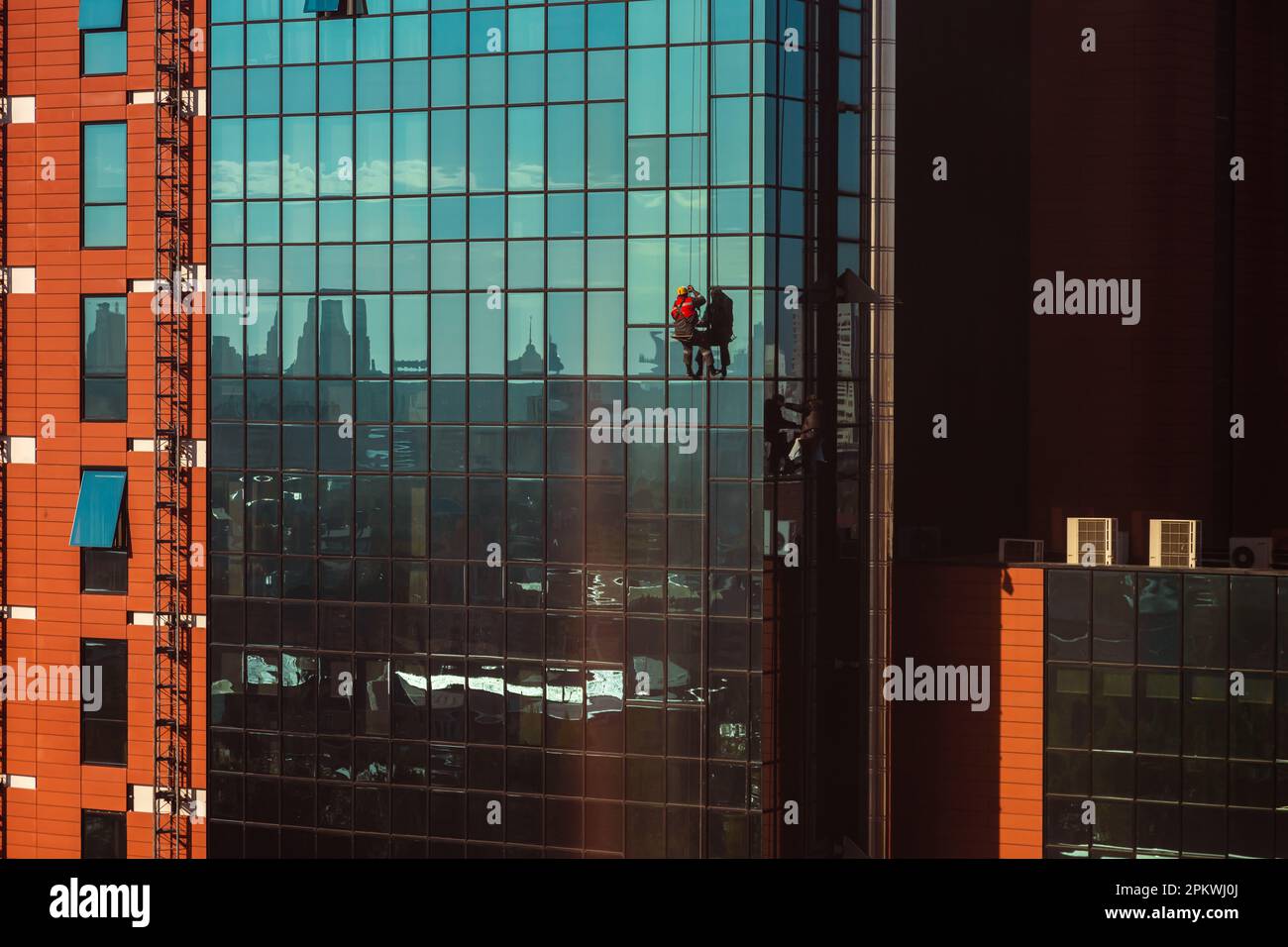 High-rise workers cleaning the windows of a skyscraper Stock Photo - Alamy
