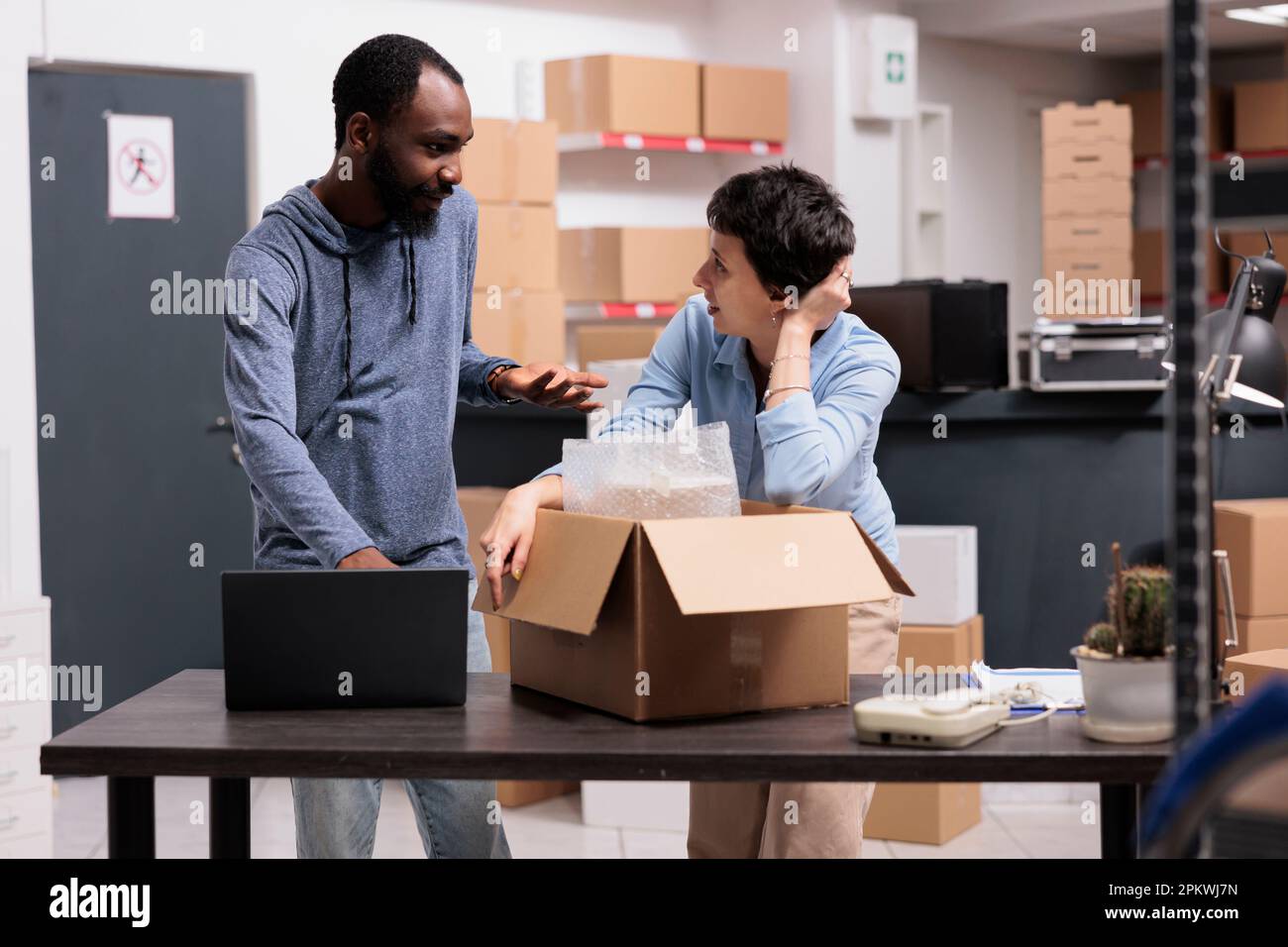 Storehouse workers discussing shipping logistics after putting client ...
