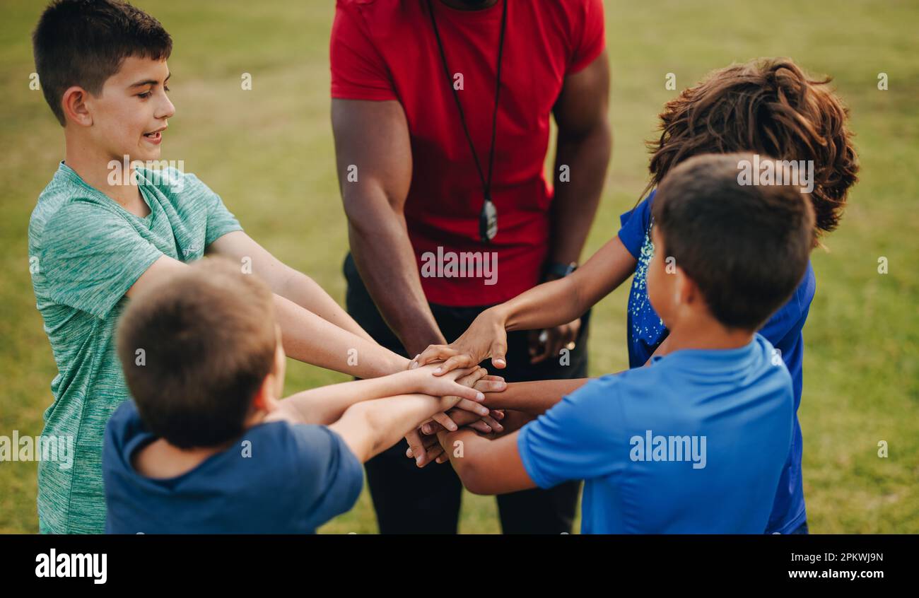 Coach and students putting their hands together in a huddle. Sports ...
