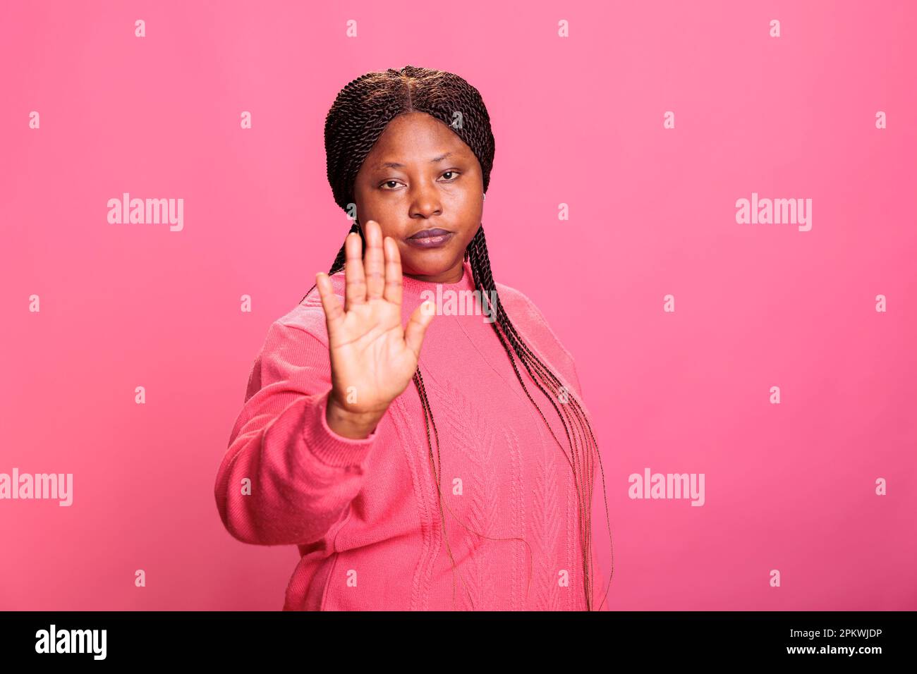 Negative woman doing stop symbol with palm expressing denial and ...