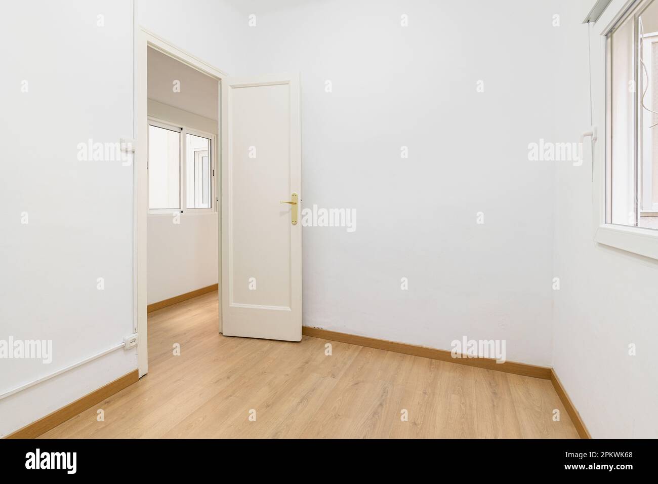 Light compact room with a small window and white walls with an open ...
