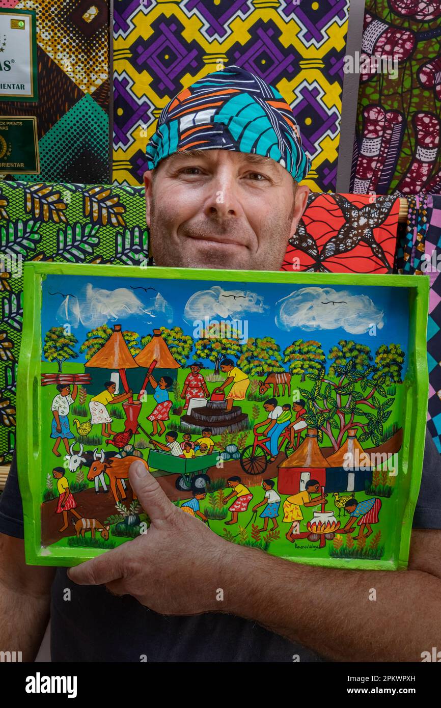 Brain Padwick, the owner of as small tobacco and craft shop, holds up a ...