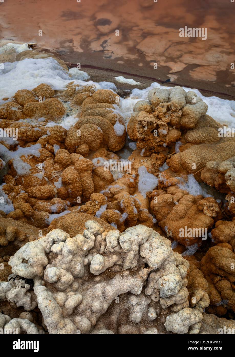 Salt and sluge build up on rocks along the salt evaporation pans of the ...