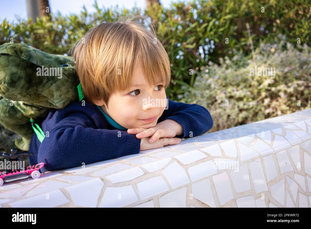 Close up Child on spring nature background. Sweet, happy child boy playing upside down on a ...