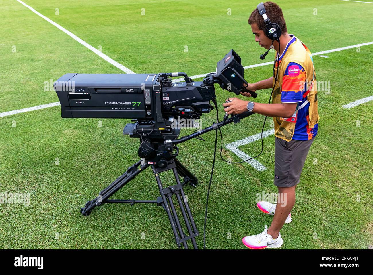 TV cameraman lining up camera on the side of the pitch at Thai league ...