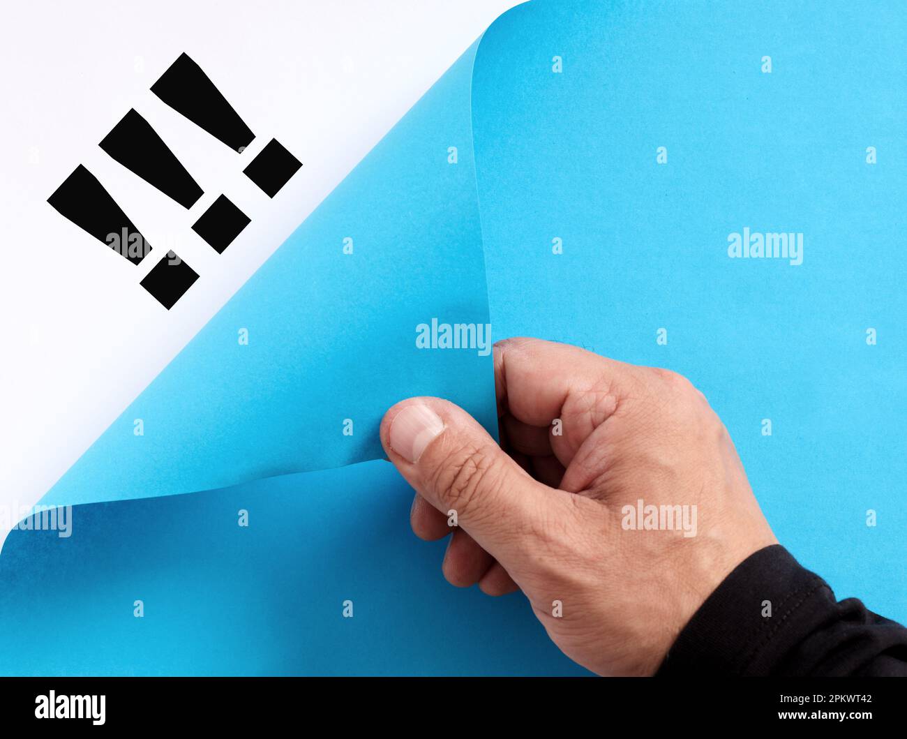Danger or threat warning concept. Male hand opens the blue paper and ...