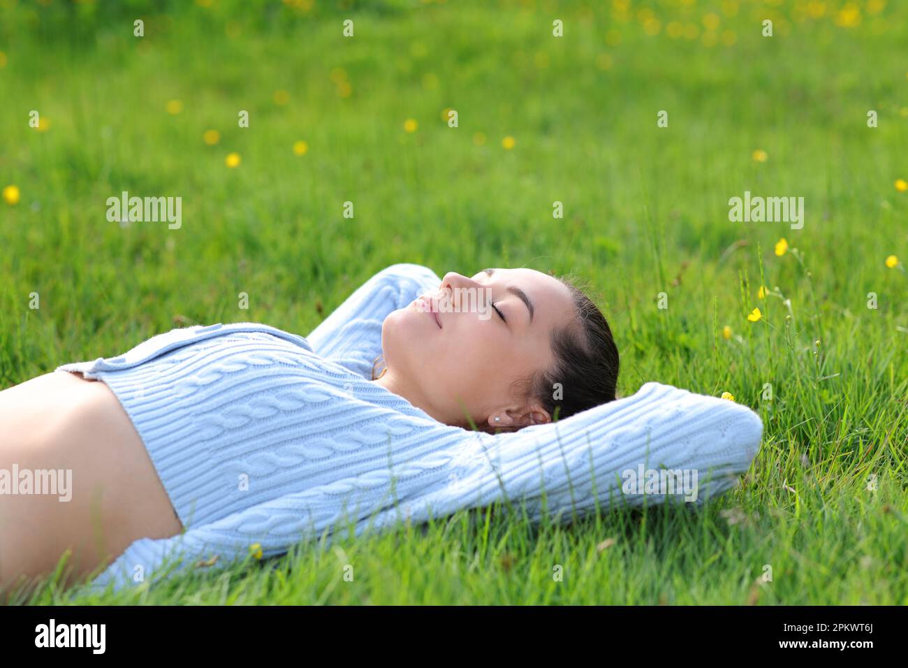 Casual woman relaxing lying on the grass in nature Stock Photo - Alamy