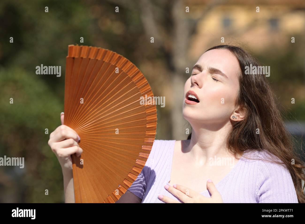 Woman in summer suffering heat stroke and fanning in a park Stock Photo ...