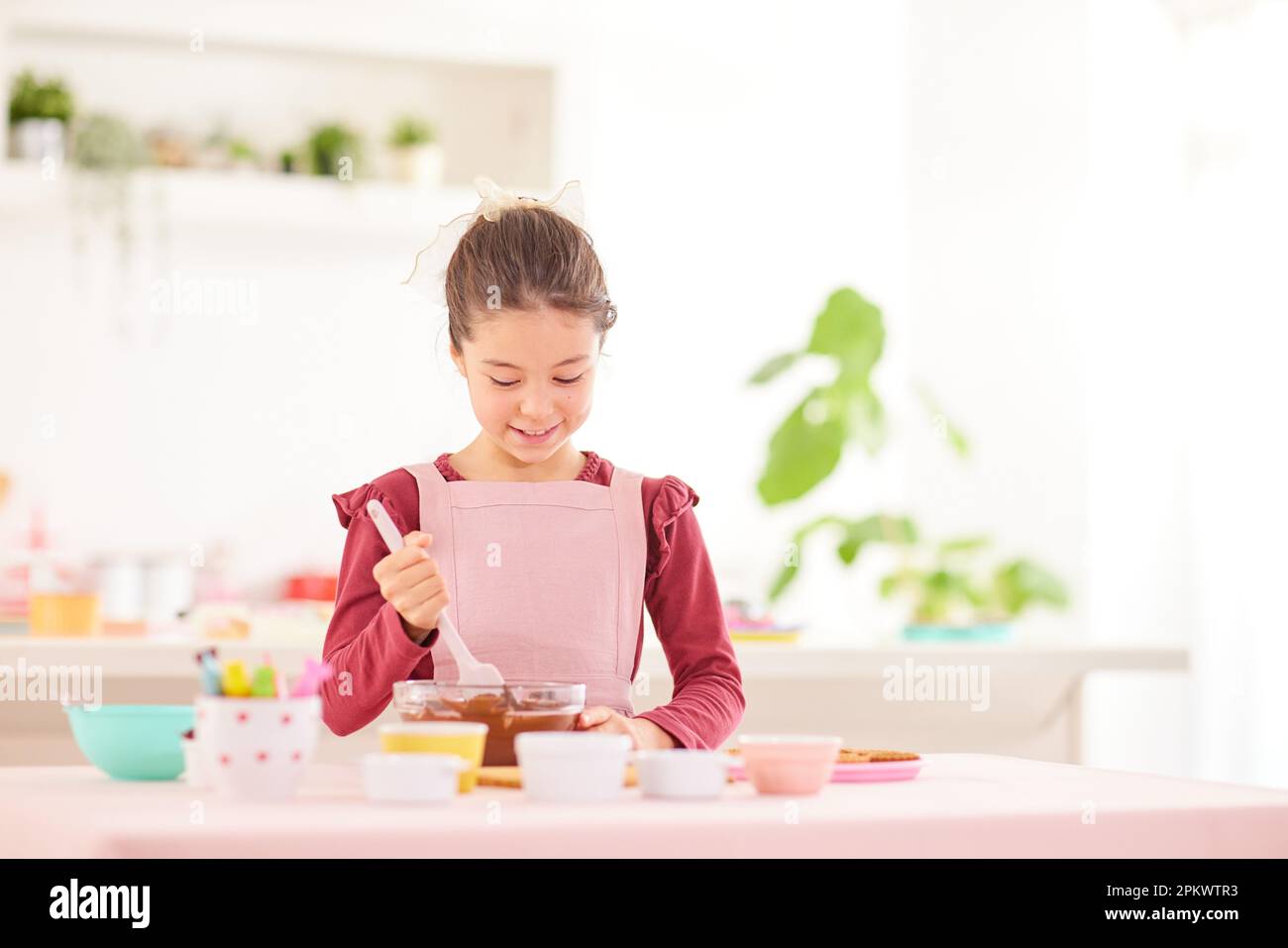 Smiling young girl making sweets Stock Photo - Alamy