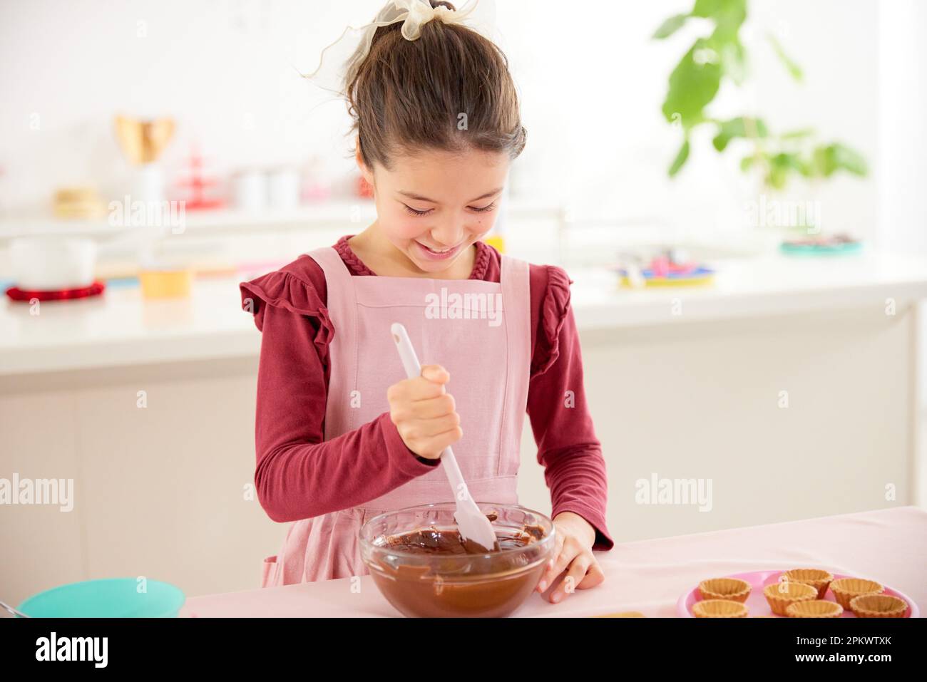 Smiling young girl making sweets Stock Photo - Alamy