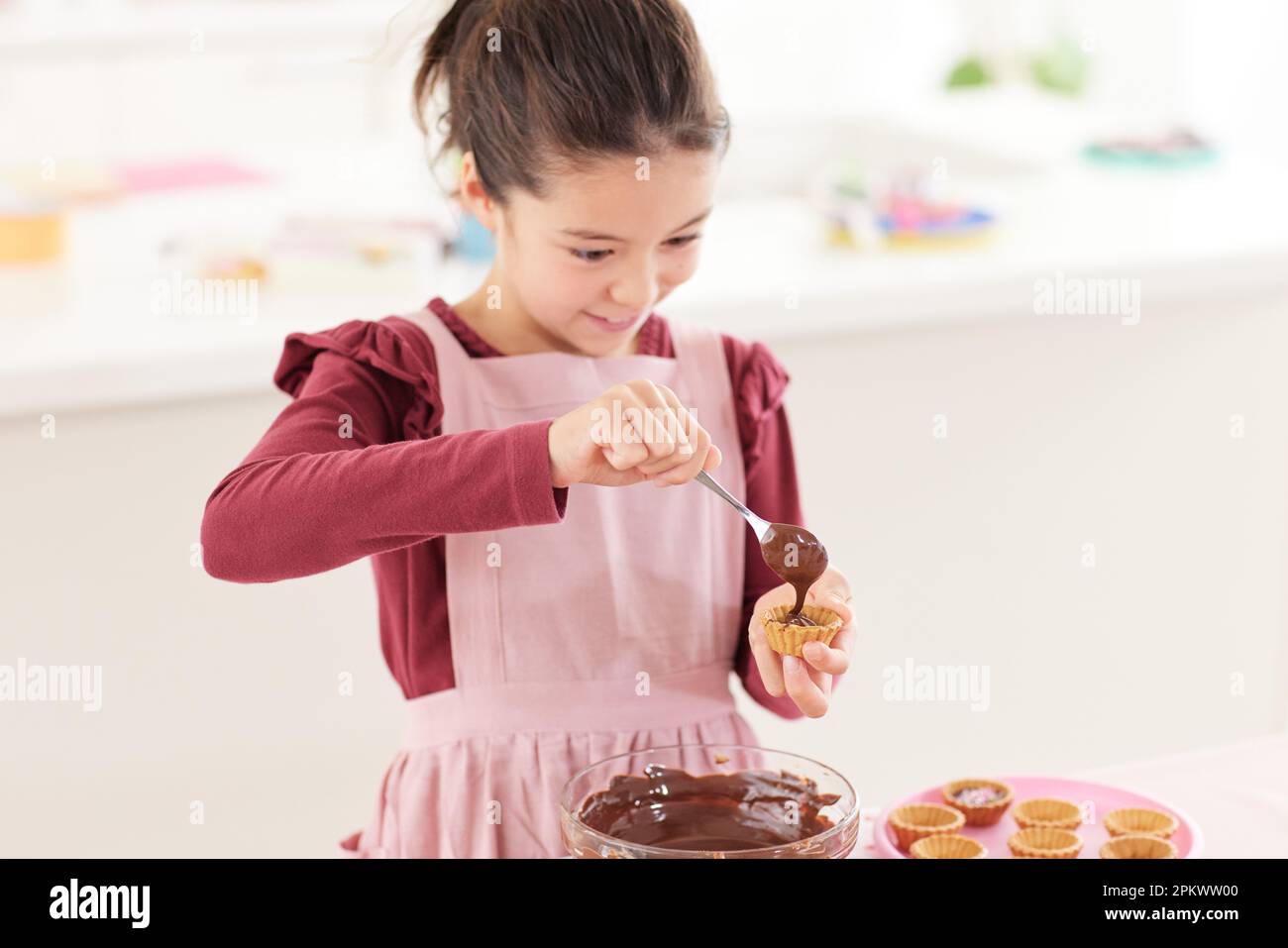 Smiling young girl making sweets Stock Photo - Alamy