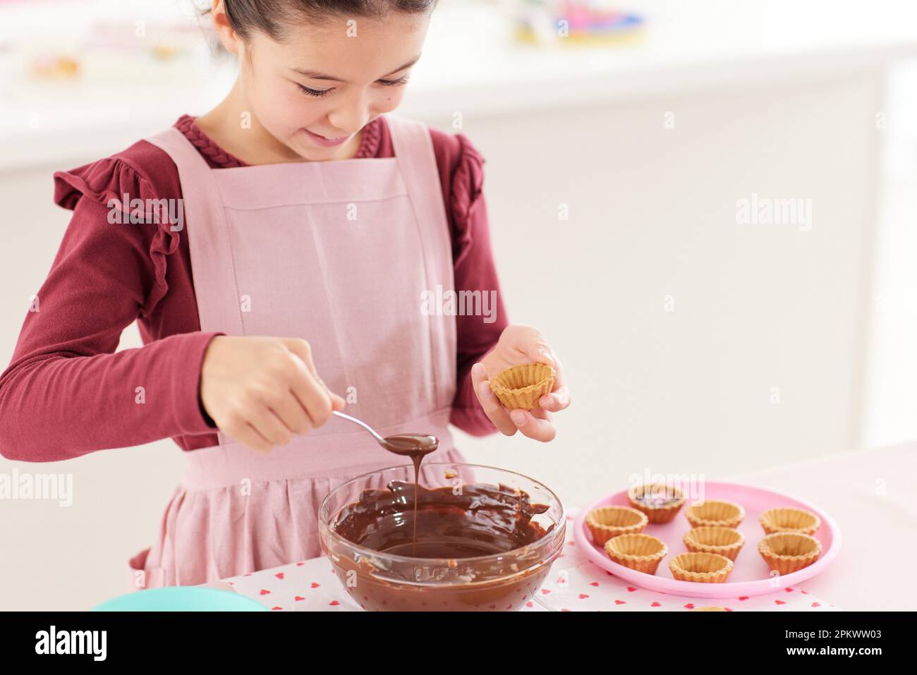 Smiling young girl making sweets Stock Photo - Alamy
