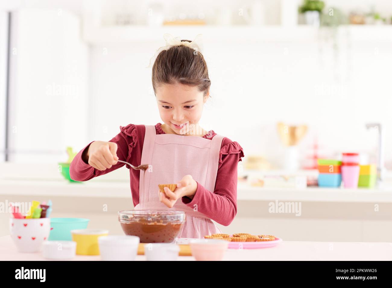 Smiling young girl making sweets Stock Photo - Alamy