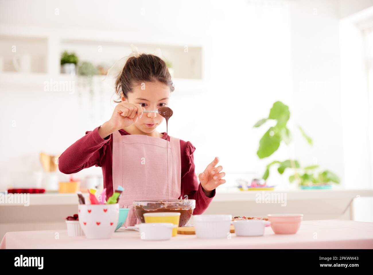Smiling young girl making sweets Stock Photo - Alamy