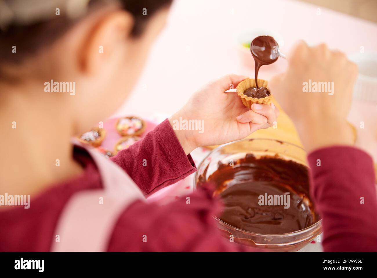 Smiling young girl making sweets Stock Photo - Alamy