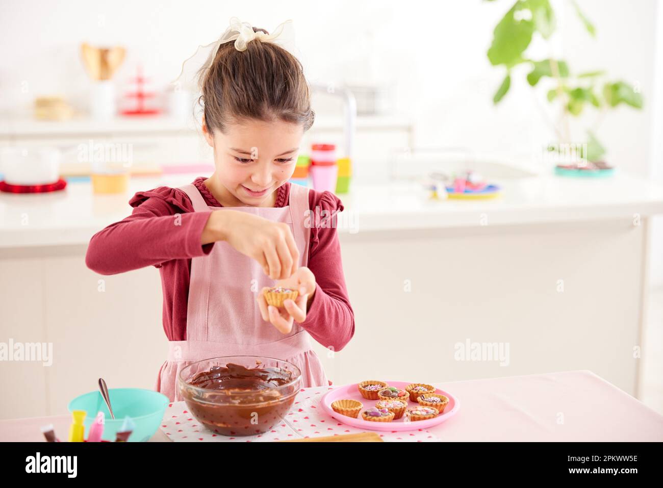 Smiling young girl making sweets Stock Photo - Alamy