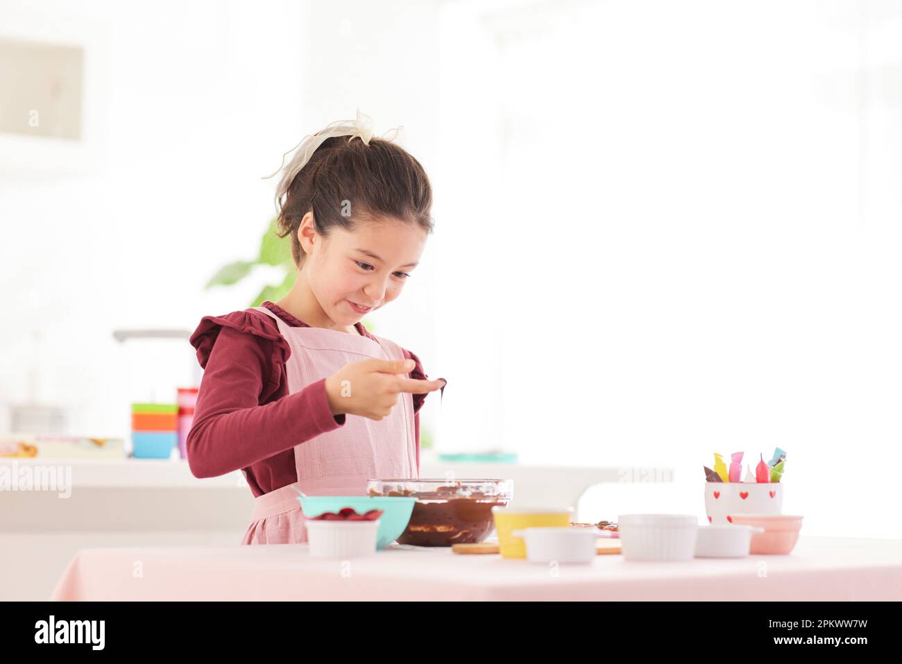 Smiling young girl making sweets Stock Photo - Alamy