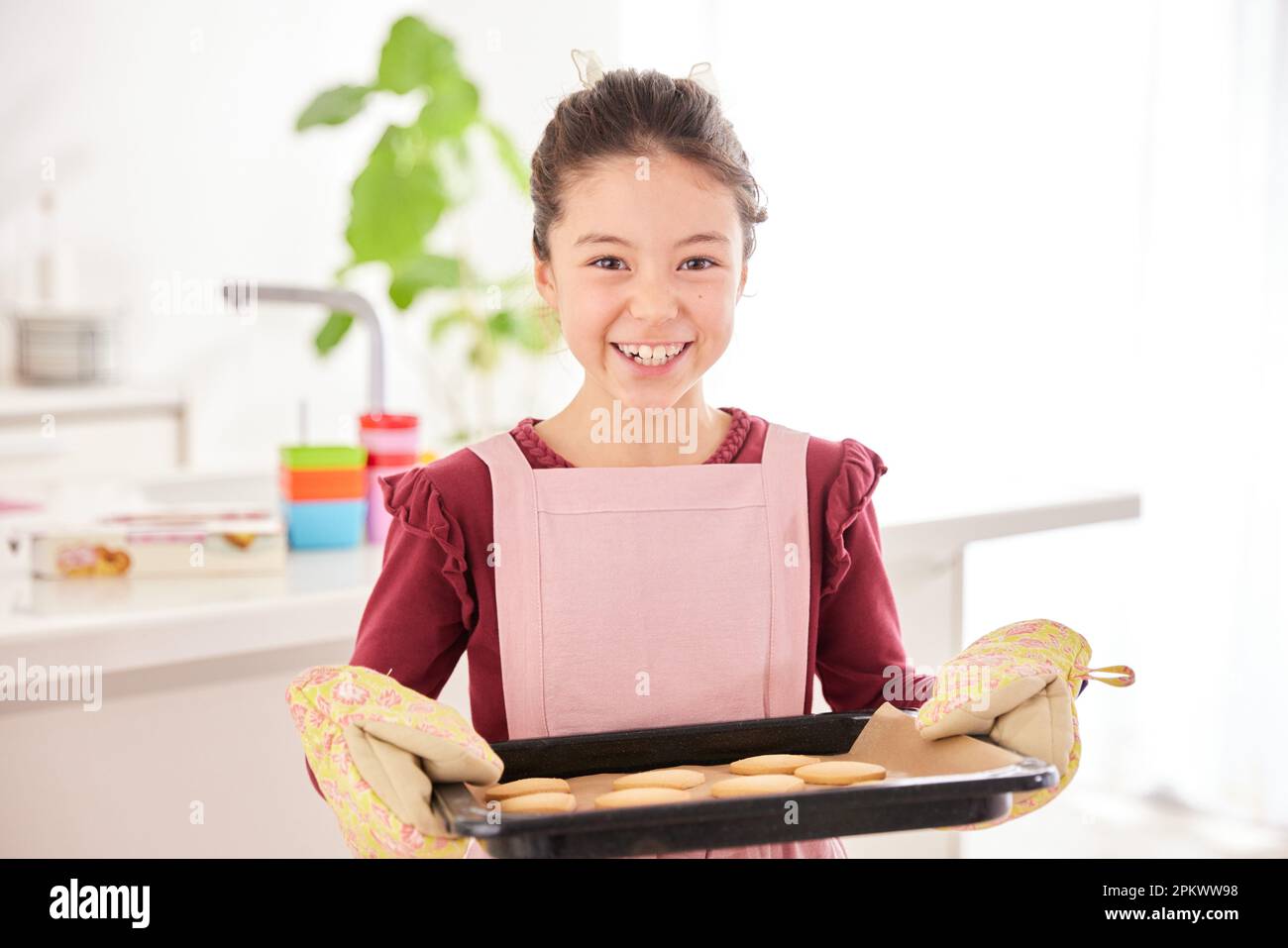 Smiling young girl making sweets Stock Photo - Alamy