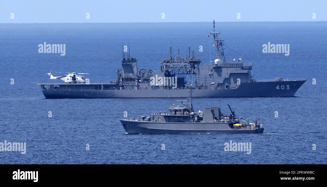 The Shishijima (background), a minesweeper vessel, and the Chihaya, a ...